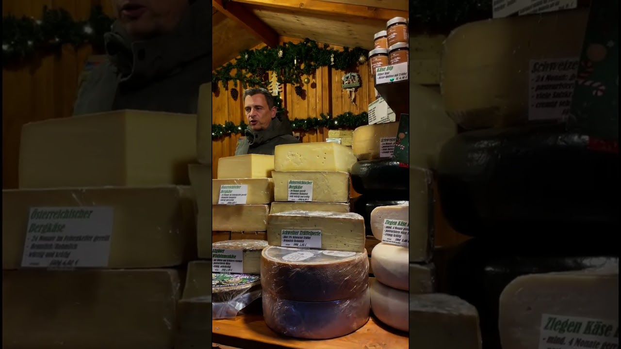 The cheese maker shows his cheese products at the Christmas market. in ...