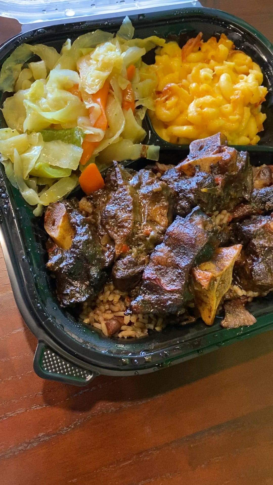 Jamaican oxtail on jollof rice with mac and cheese and cabbage. - La ...
